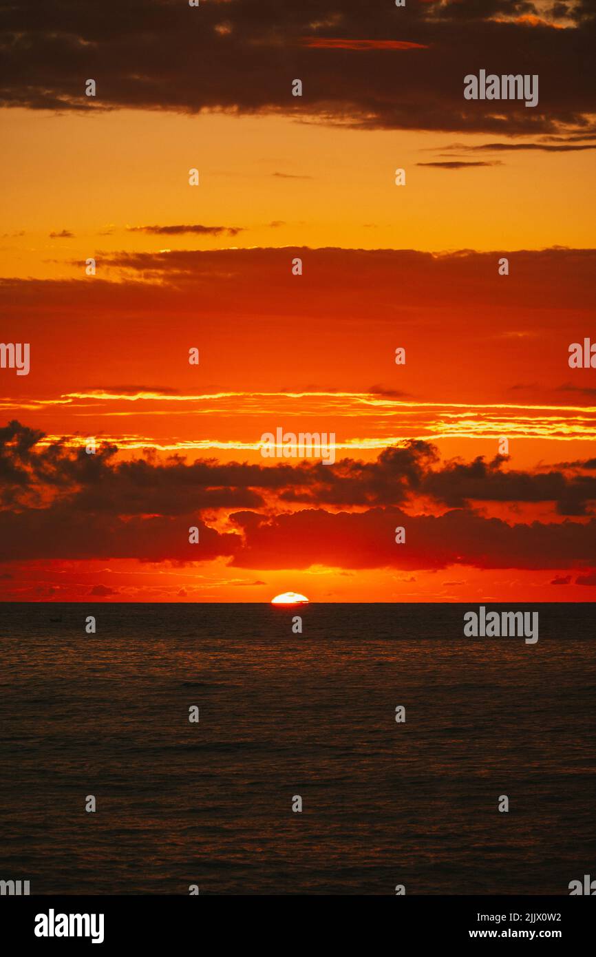 Orange colorful sundown sky with clouds near sea Stock Photo - Alamy