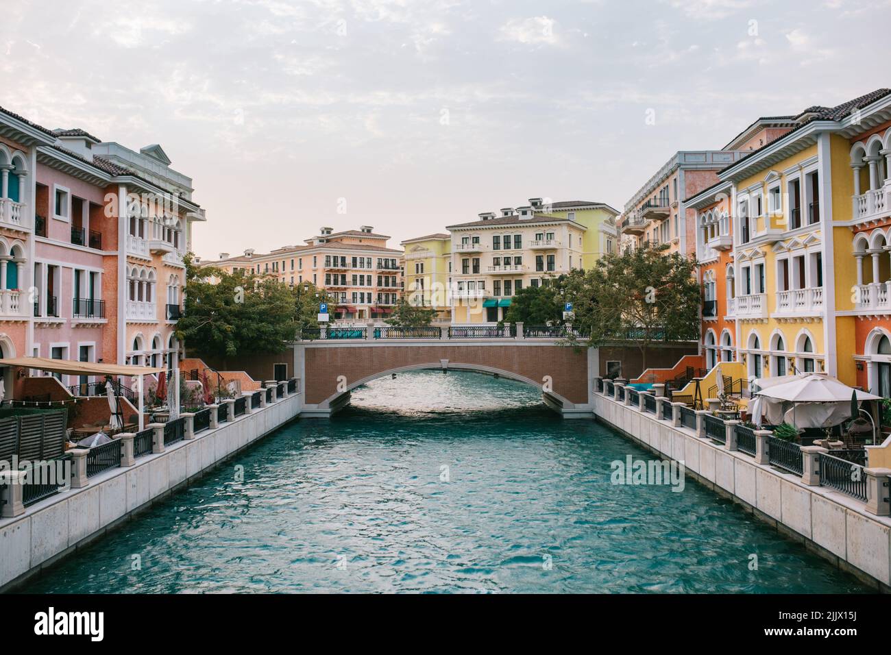 Ornamental houses and simple bridge located near canal with clean water ...