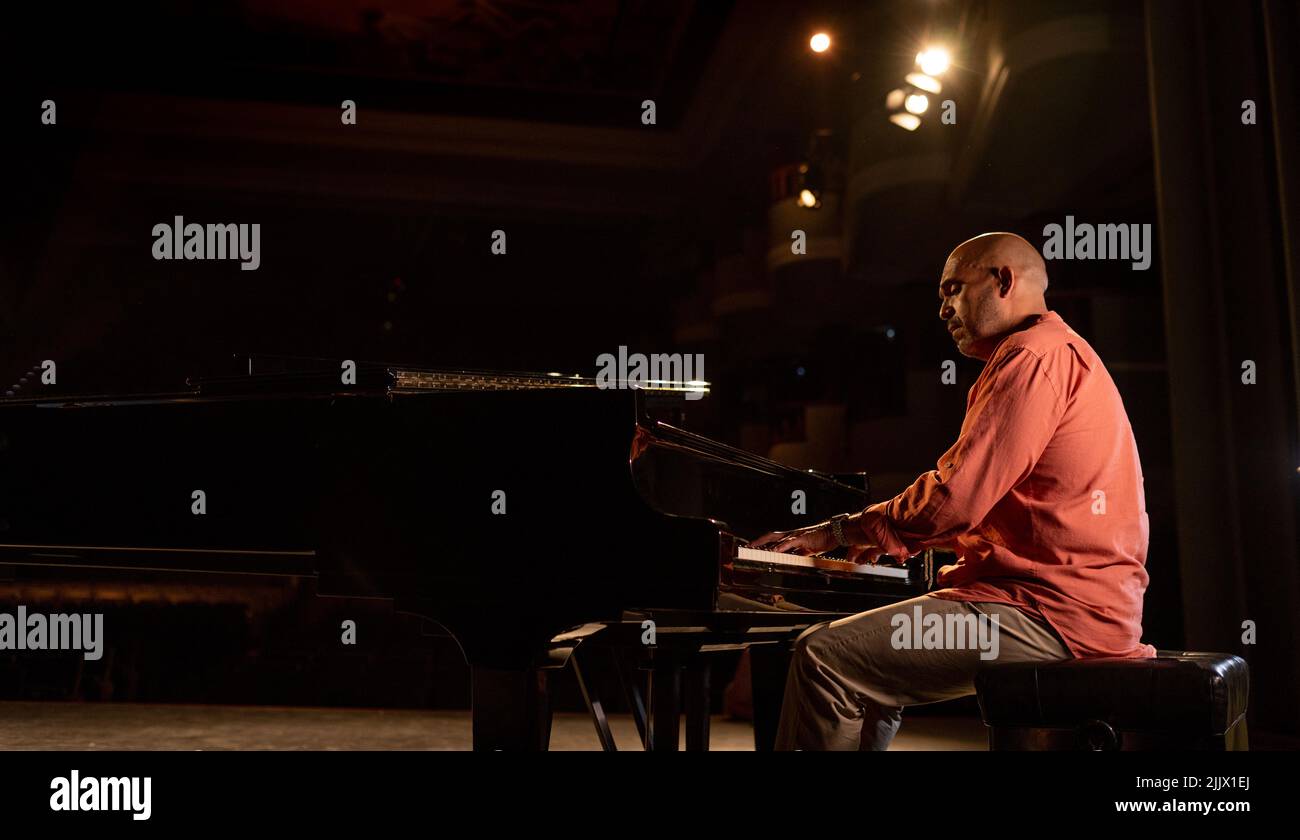 Side view of focus bald male musician playing piano during performance ...