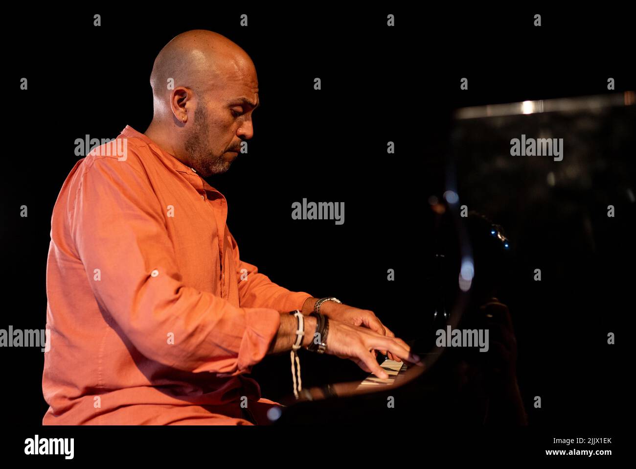 Side view of focus bald male musician playing piano during performance ...