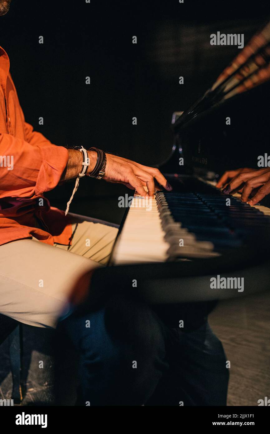 Cropped side view of unrecognizable male musician playing piano during ...