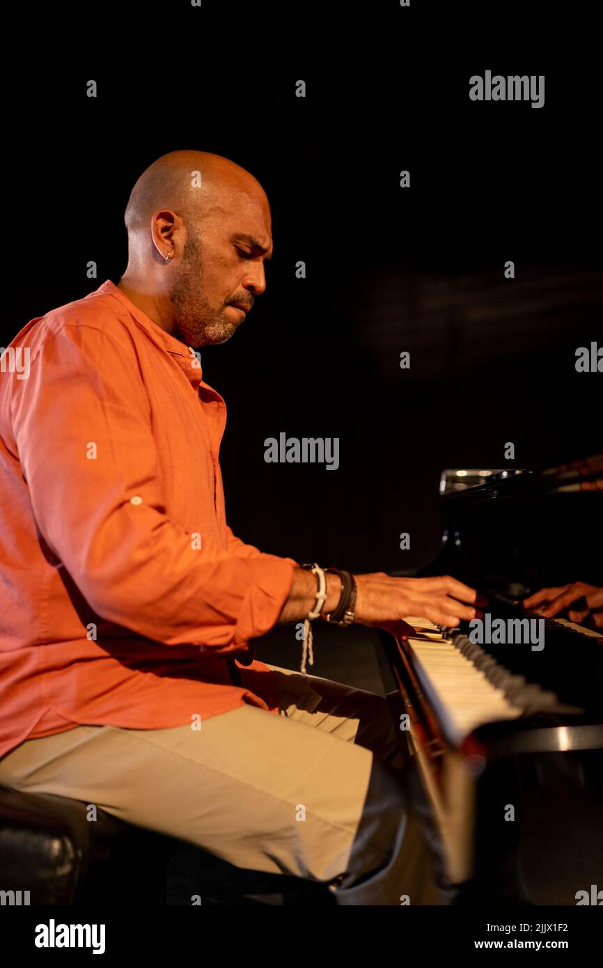 Side view of focus bald male musician playing piano during performance ...