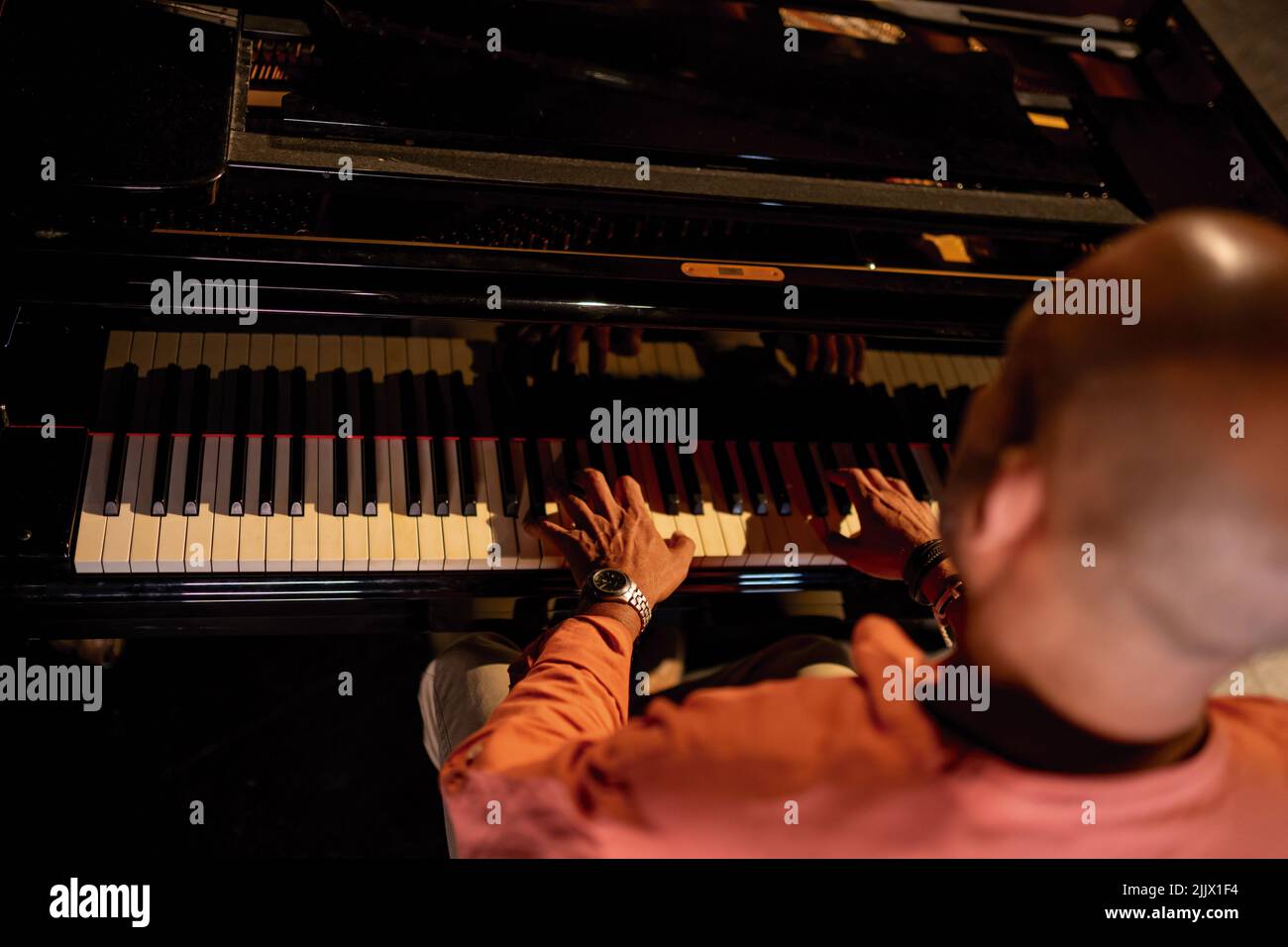From above unrecognizable bald male musician playing piano during ...