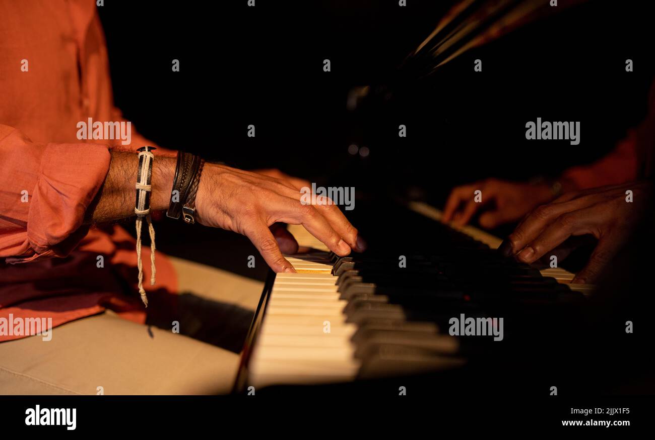 Cropped side view of unrecognizable male musician playing piano during ...