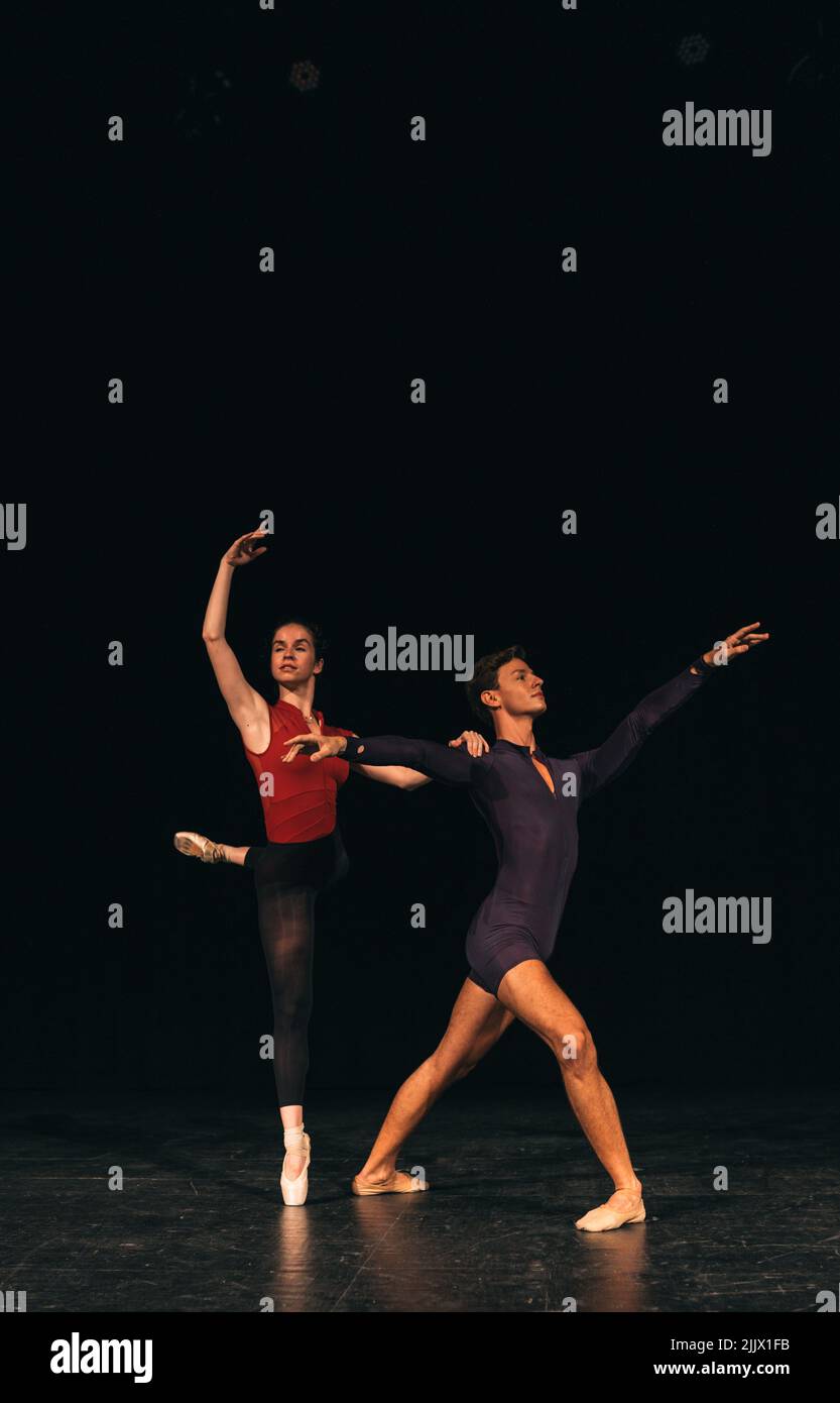 Full body danseur dancing with ballerina on dark stage during rehearsal ...