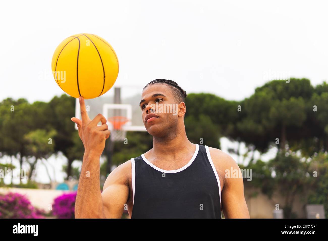 Concentrated African American basketball player spinning ball on finger ...