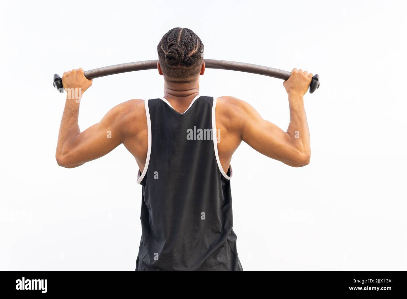 Low angle back view of unrecognizable Hispanic male athlete doing pull ...