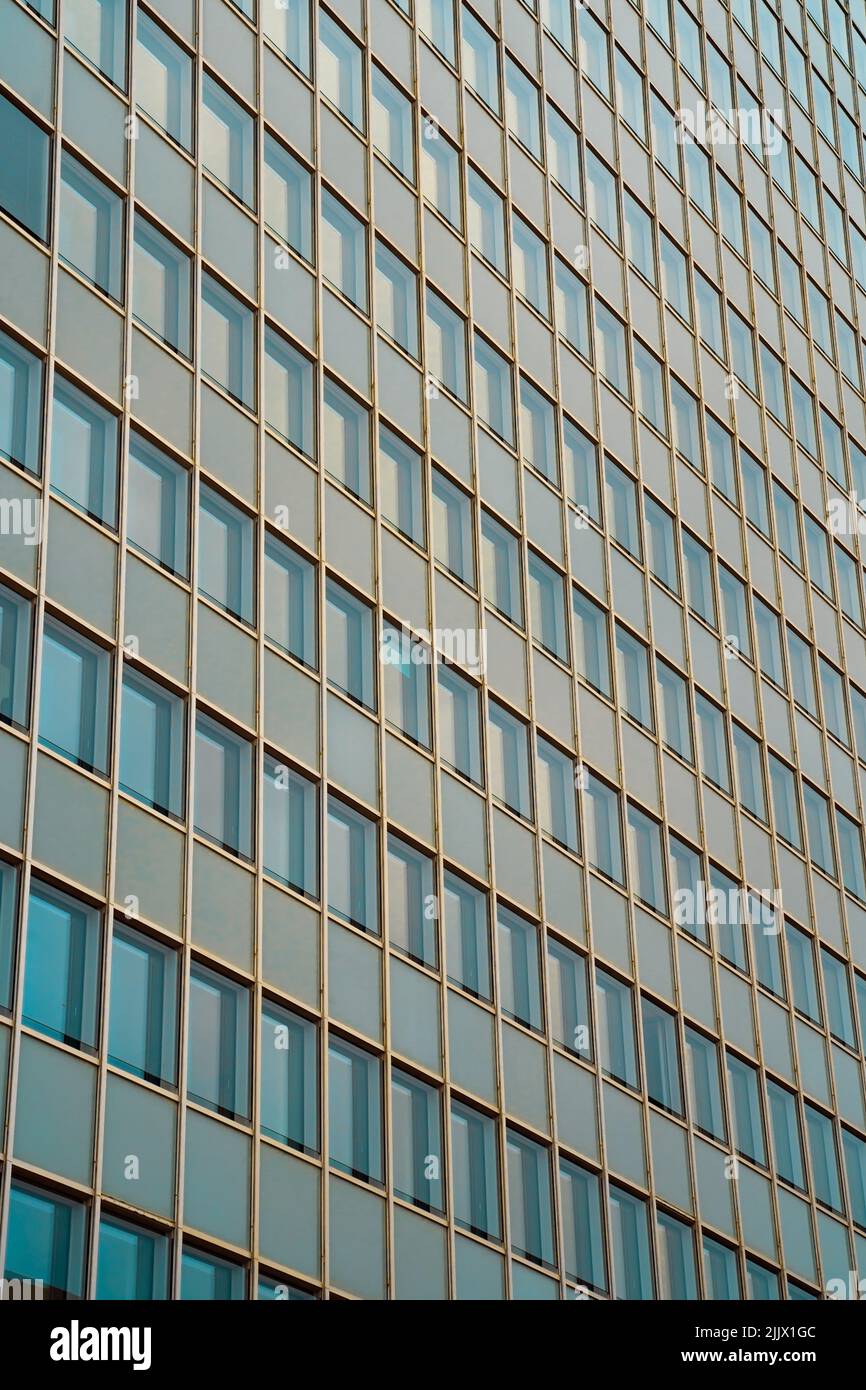 Low angle of modern geometric high building with dense mirrored windows ...