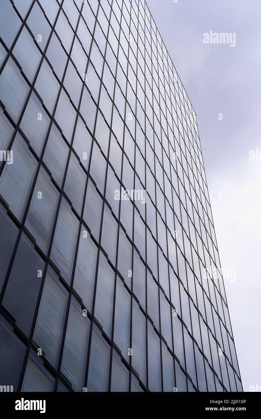 Low angle of modern geometric high building with dense mirrored windows ...