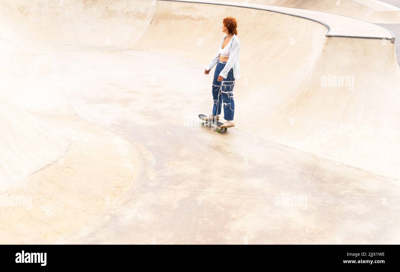 From above full body side view of active female in casual wear riding ...