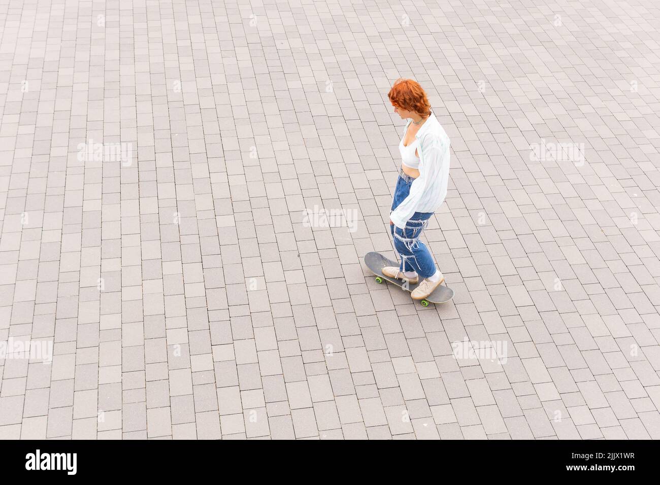 From above full body side view of active female in casual wear riding ...