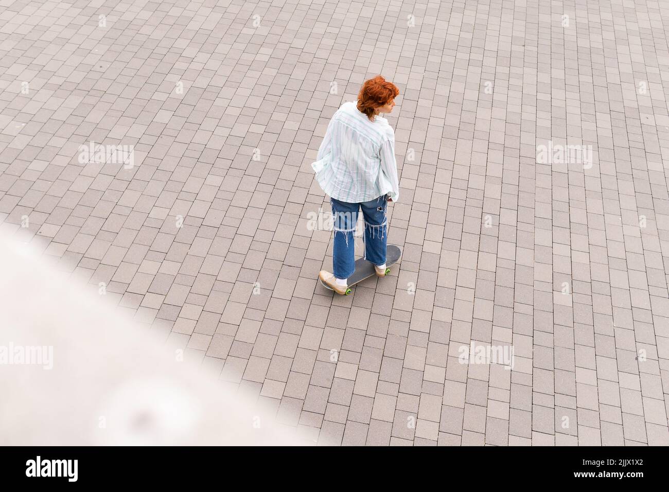 From above full body side view of active female in casual wear riding ...
