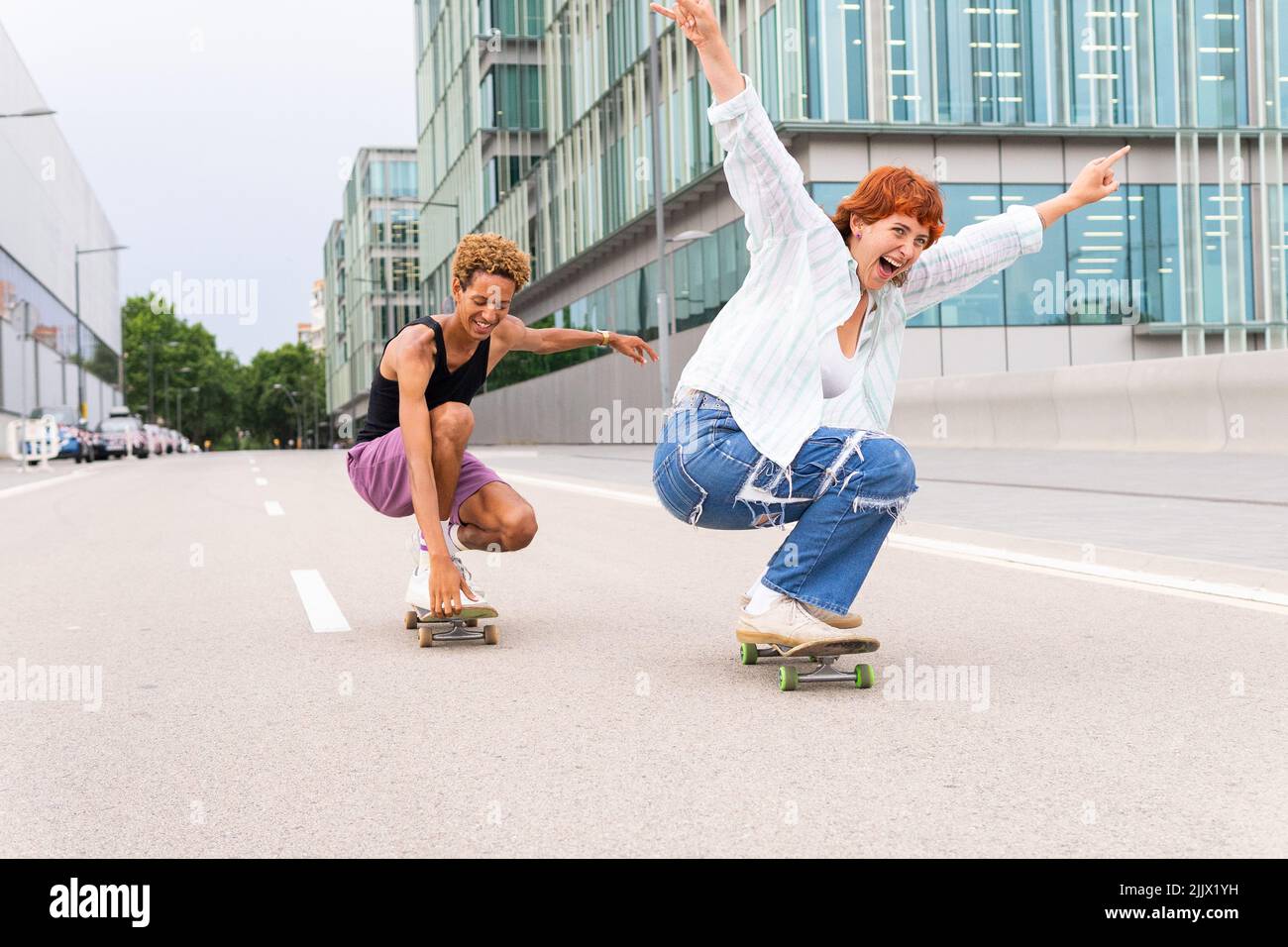 Full body of happy multiracial friends in casual wear riding ...