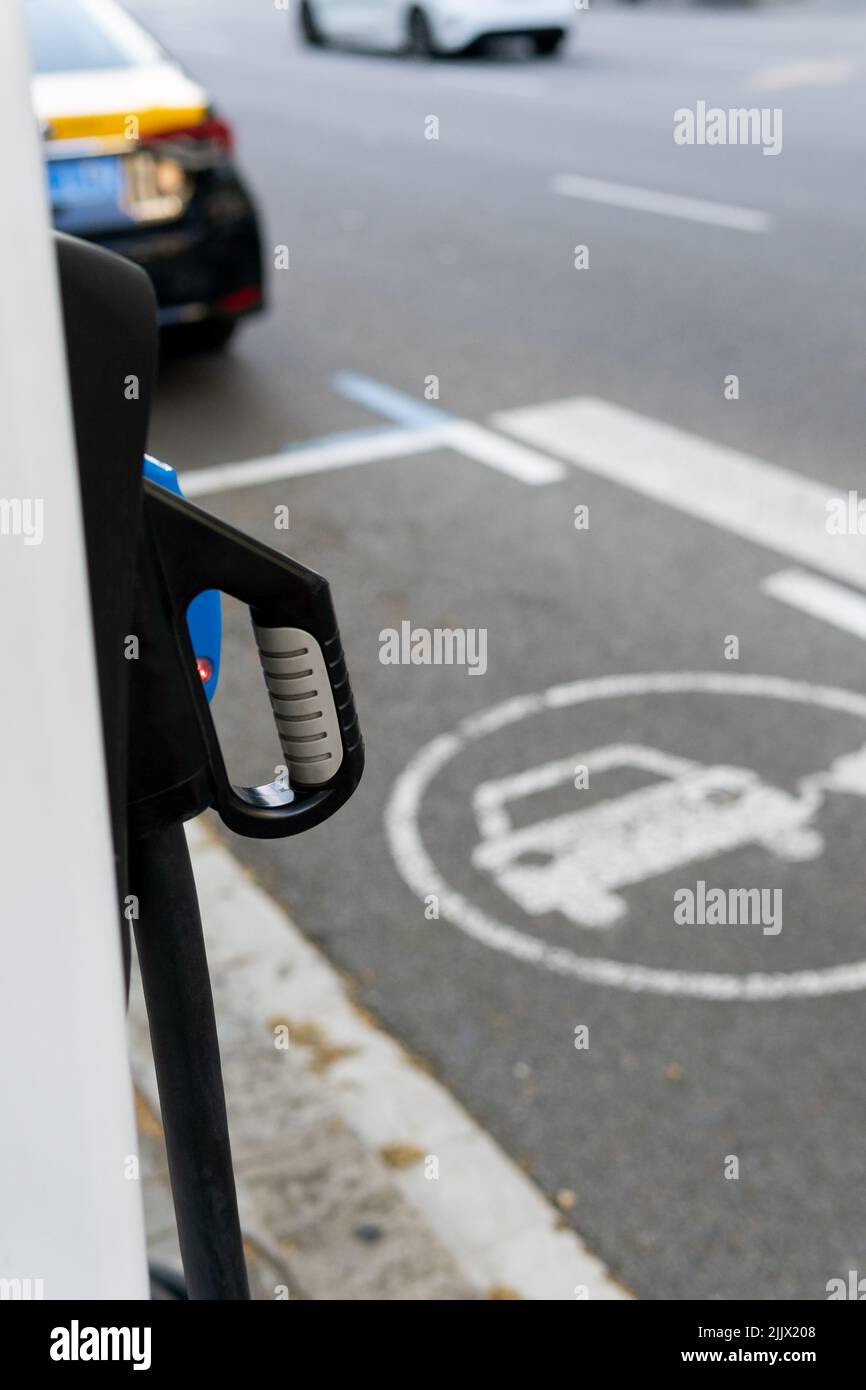 White sign of electric automobile charging on asphalt road at car ...