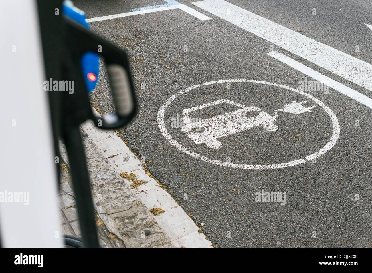 White sign of electric automobile charging on asphalt road at car ...