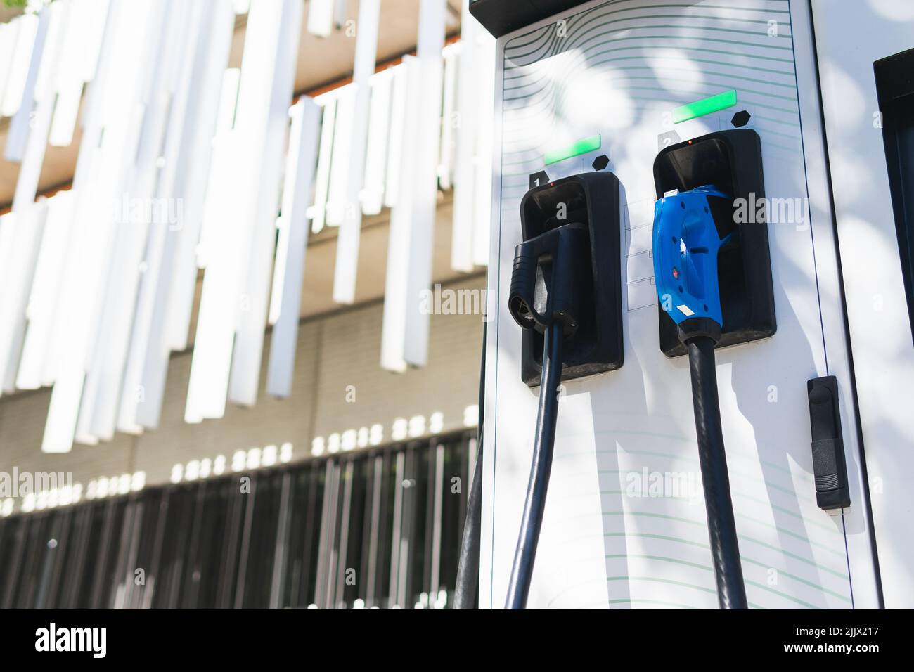 Contemporary public electric vehicle charging station with gun chargers ...
