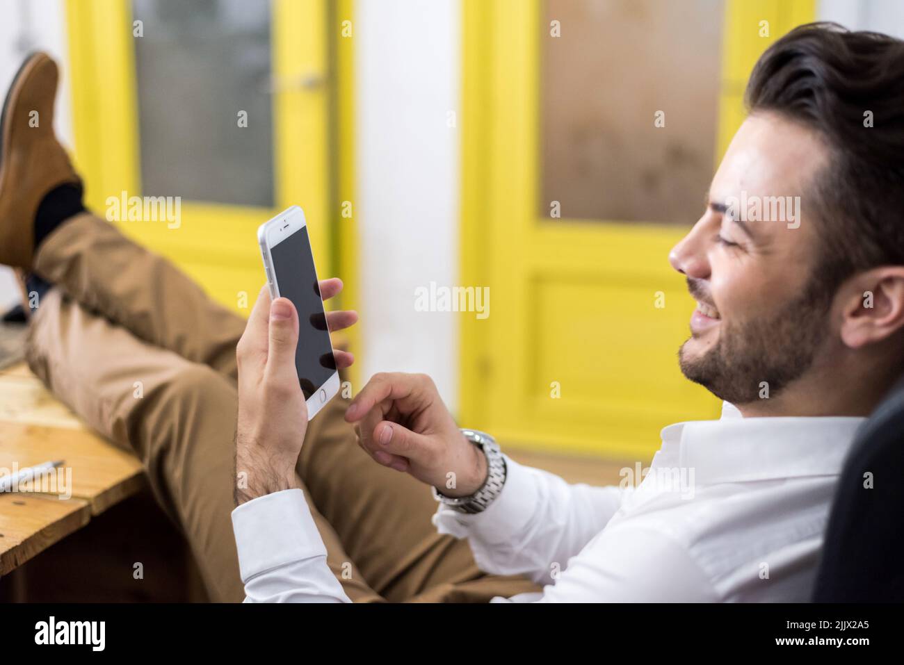 Side view of crop male worker surfing internet on cellphone with black ...