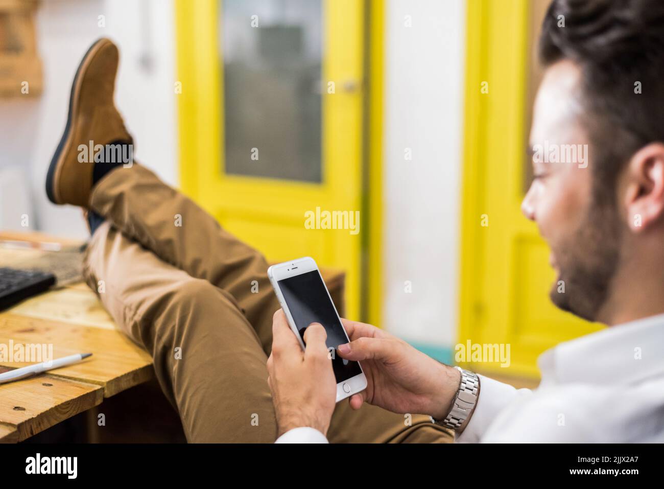 Side view of crop male worker surfing internet on cellphone with black ...