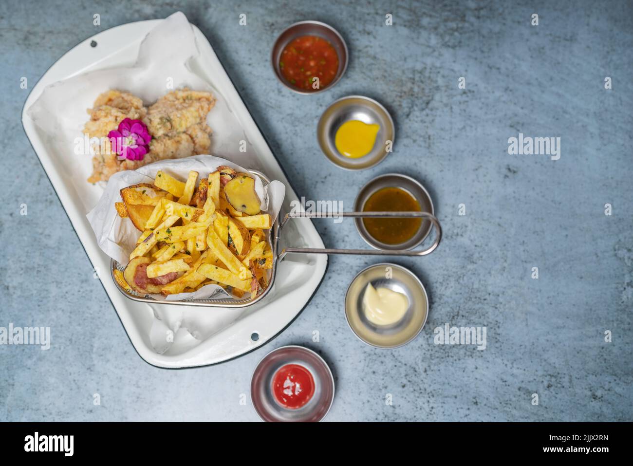 Top view of tasty fried potatoes with breaded chicken wings placed on ...