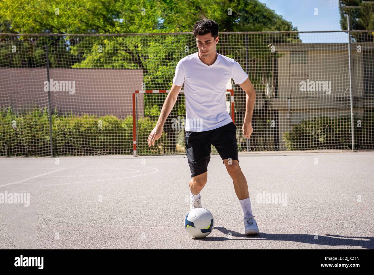 Full body of young man playing soccer in court Stock Photo - Alamy