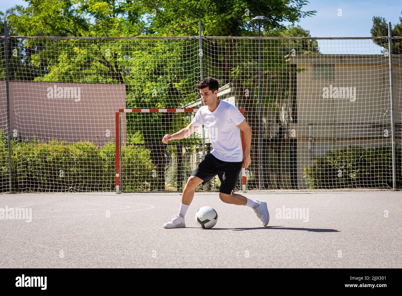 Full body of young man playing soccer in court Stock Photo - Alamy