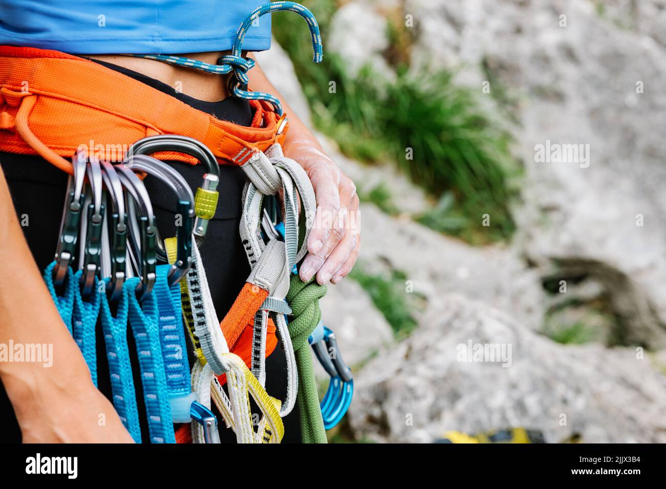 Crop side view of man wearing harness belt with plenty of carabiners ...