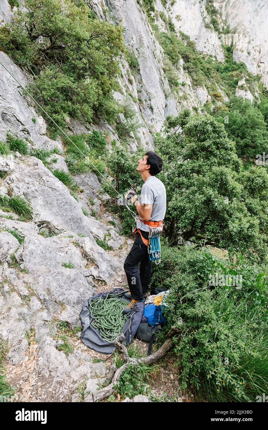 Side view of man holding safety cable looking above while belaying highlander Stock Photo - Alamy