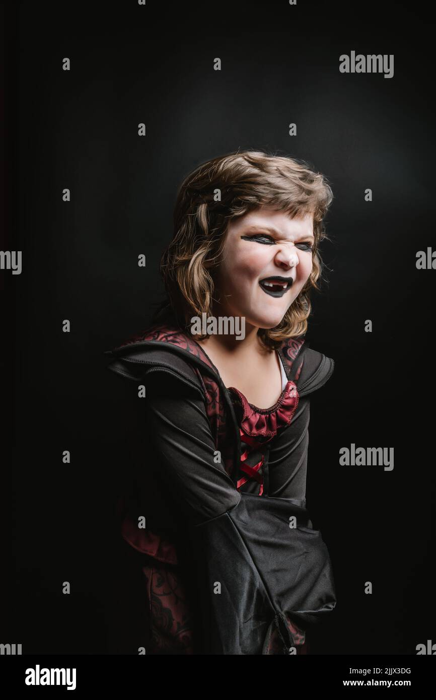Creepy little girl with dark makeup in enchantress costume making scary ...