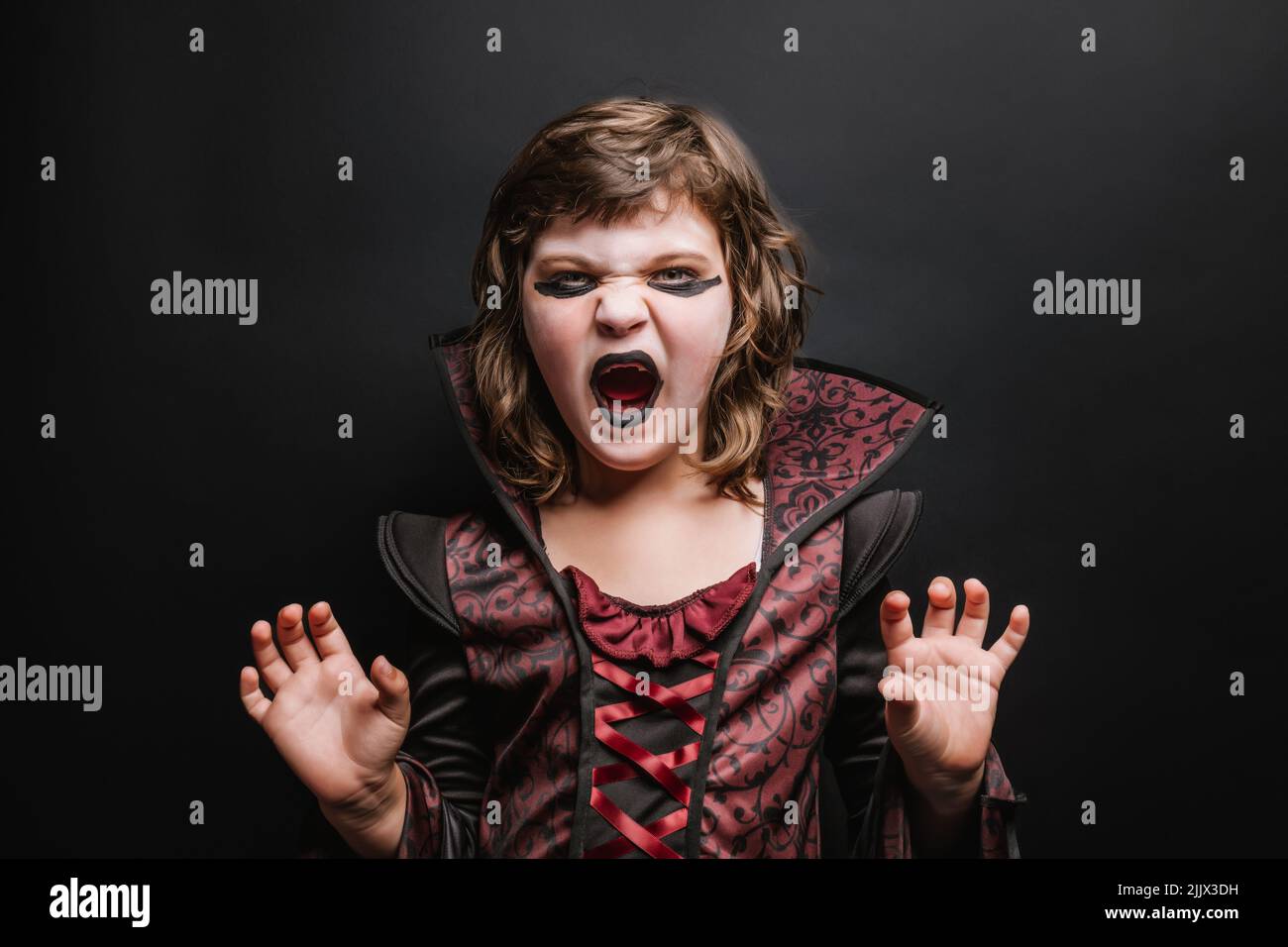 Creepy little girl with dark makeup in enchantress costume making scary ...