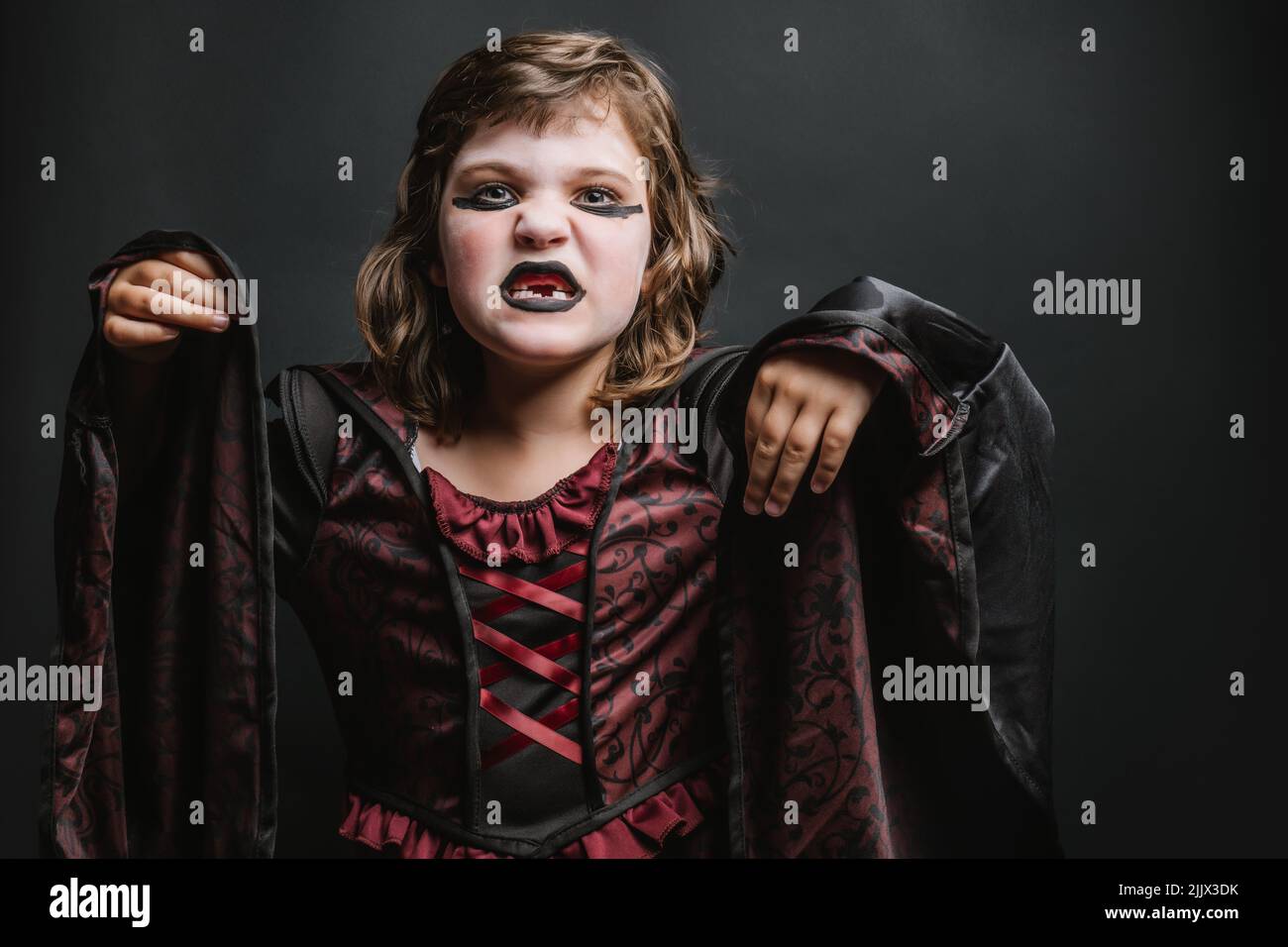 Creepy little girl with dark makeup in enchantress costume making scary ...