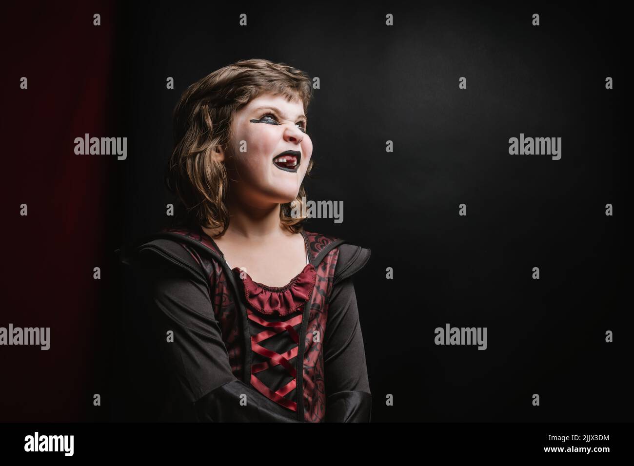 Creepy little girl with dark makeup in enchantress costume making scary ...