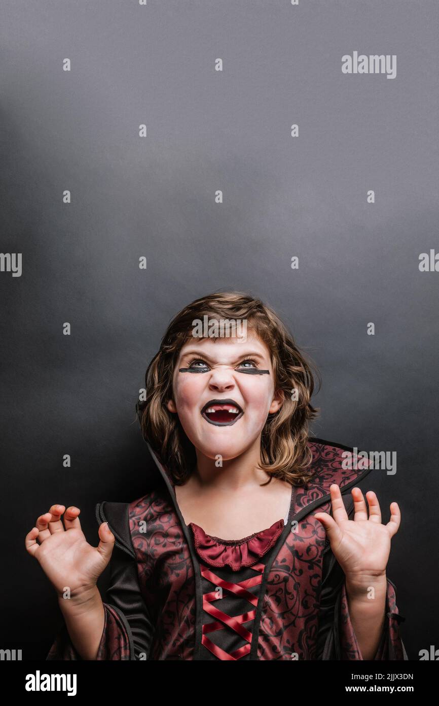 Creepy little girl with dark makeup in enchantress costume making scary ...