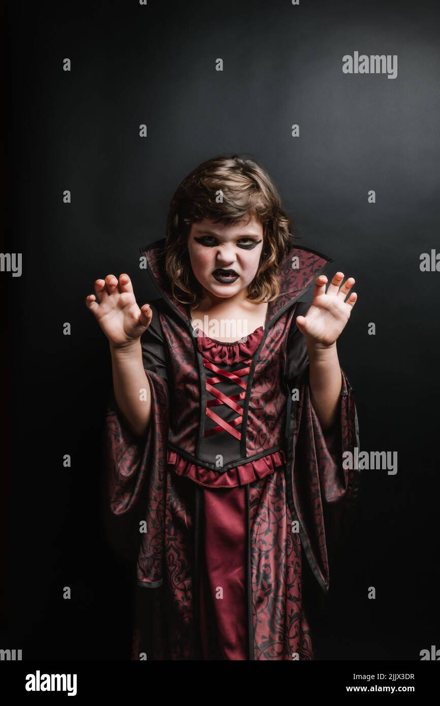 Creepy little girl with dark makeup in enchantress costume making scary ...