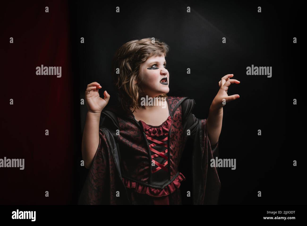 Creepy little girl with dark makeup in enchantress costume making scary ...