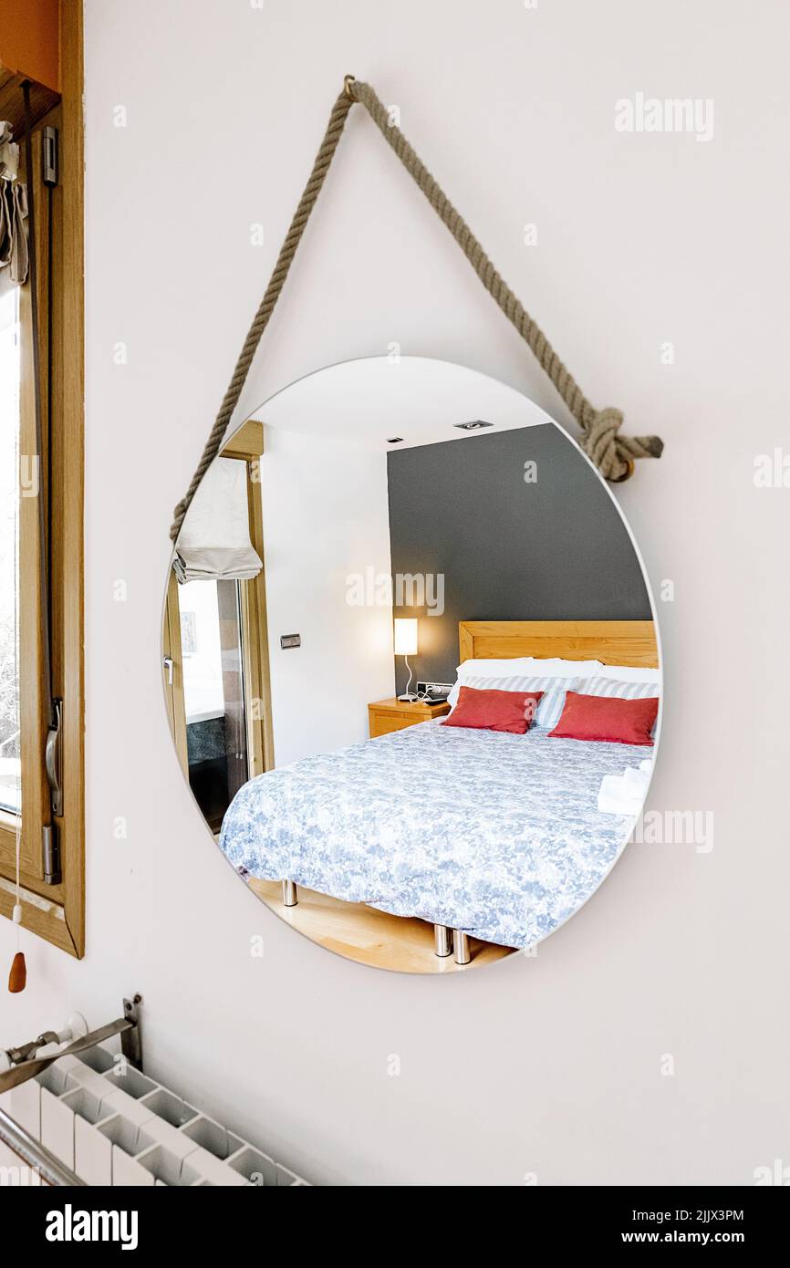 Round shaped mirror hanging on white wall and reflecting conformable ...
