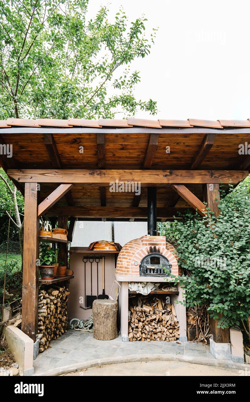 Traditional rustic furnace with pile of chopped firewood in wooden ...