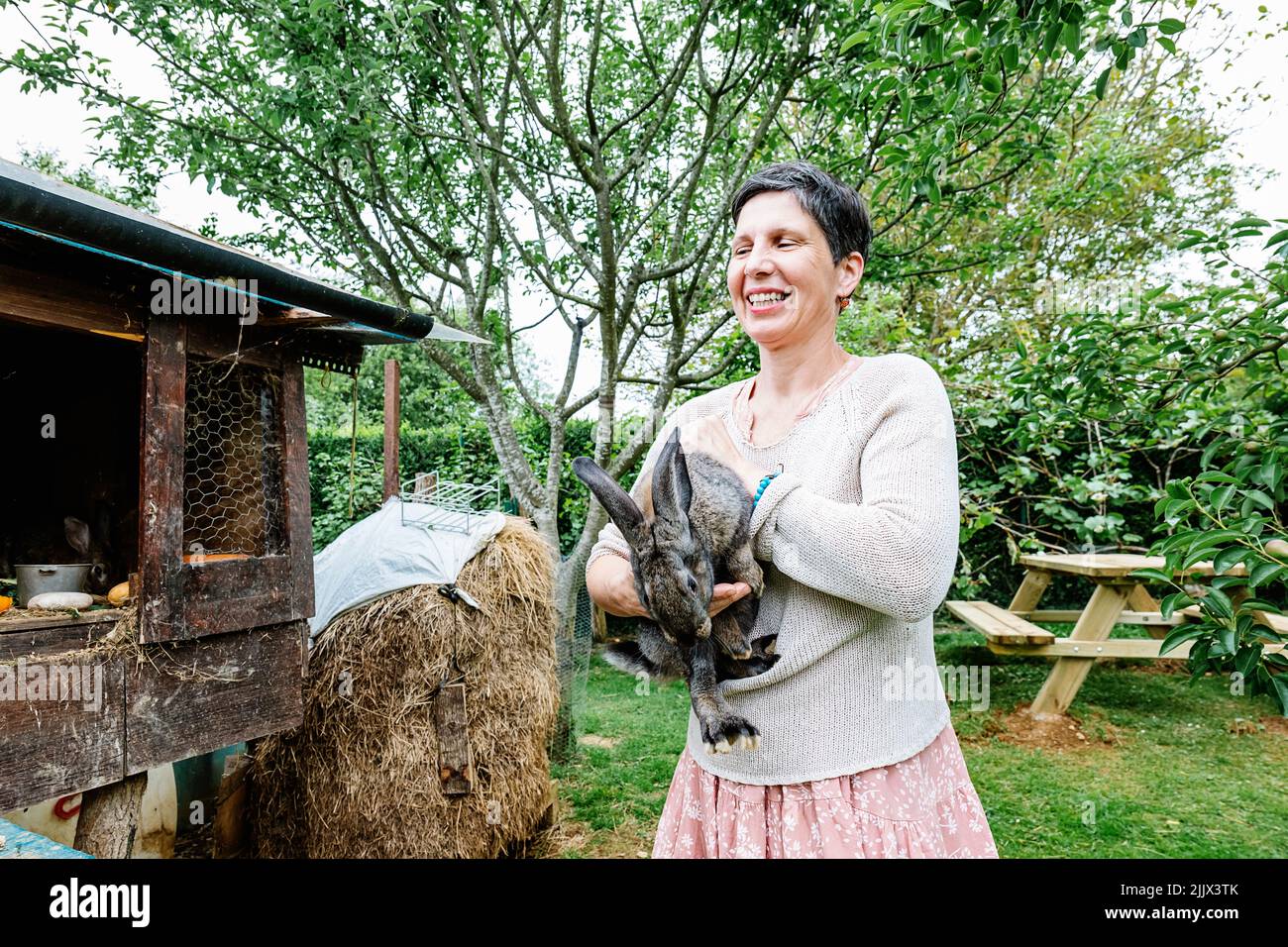 Cheerful middle aged female farmer with short dark hair in casual ...