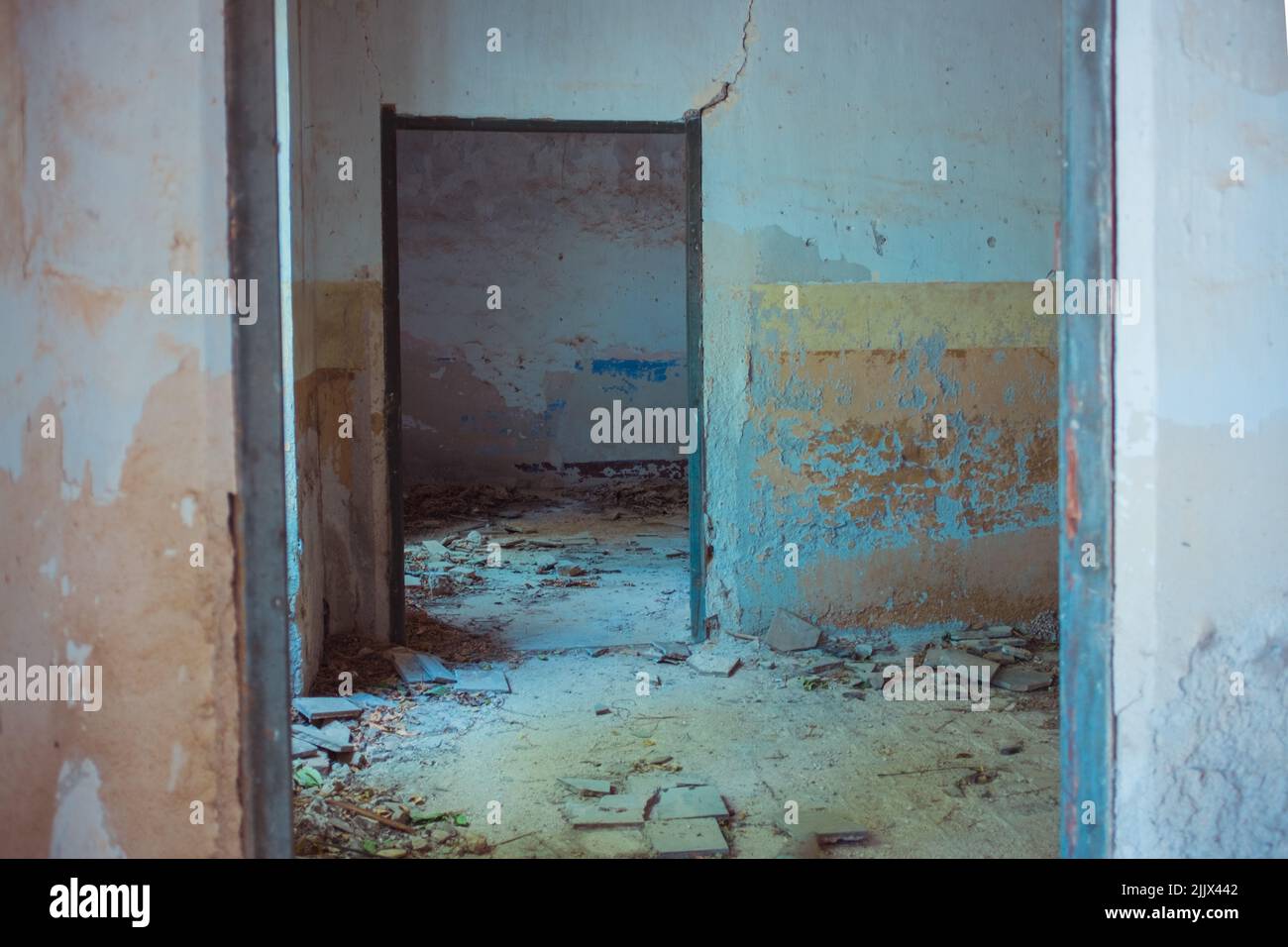 Interior of corridor with shabby doorways and crumbling plaster walls ...