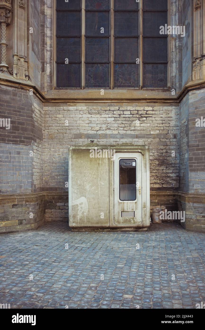 Desolate brick building with shabby door and huge window located near ...