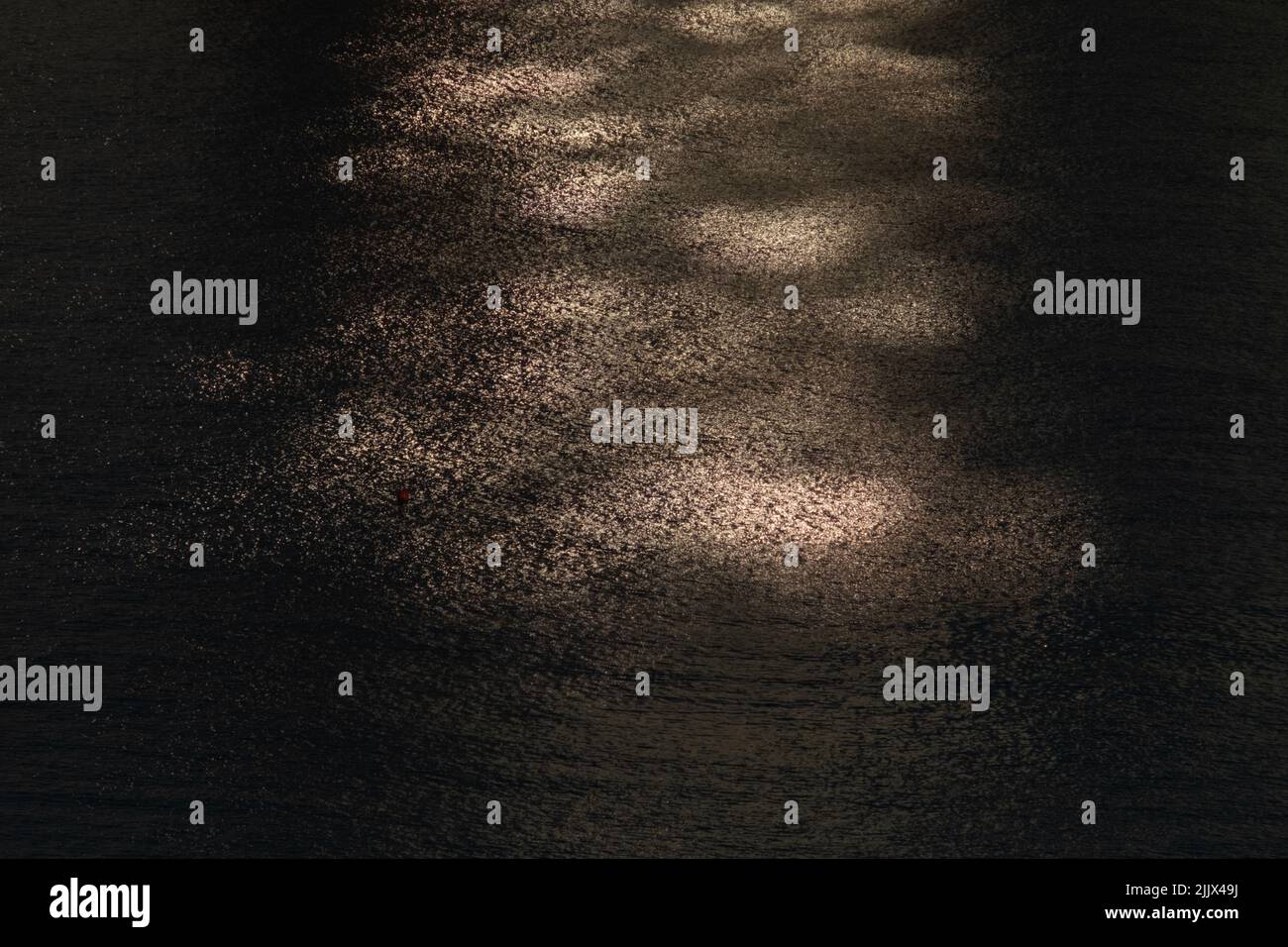 From above dry sandy ground covered with dark shadows of trees foliage ...