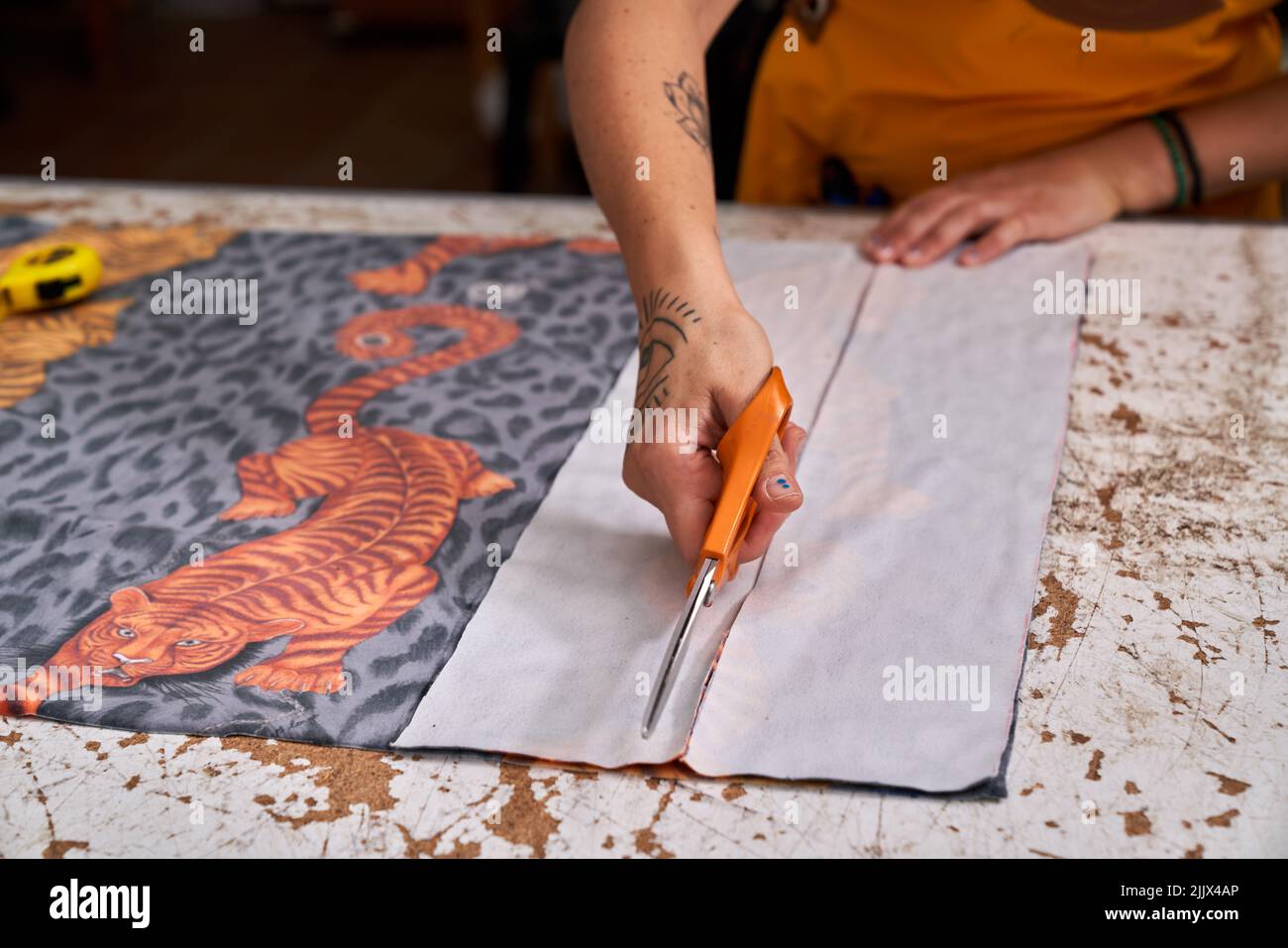 Anonymous adult female designer cutting fabric with scissors standing ...
