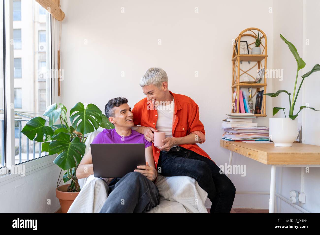 Happy gay couple using laptop hi-res stock photography and images - Alamy