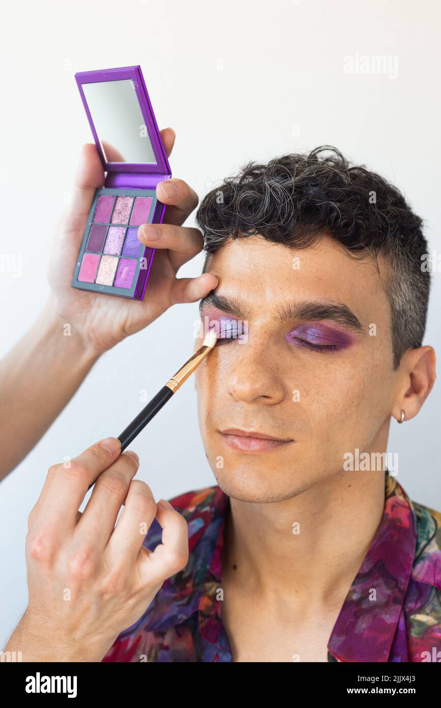 Caucasian transgender man getting makeup done by his boyfriend at home ...