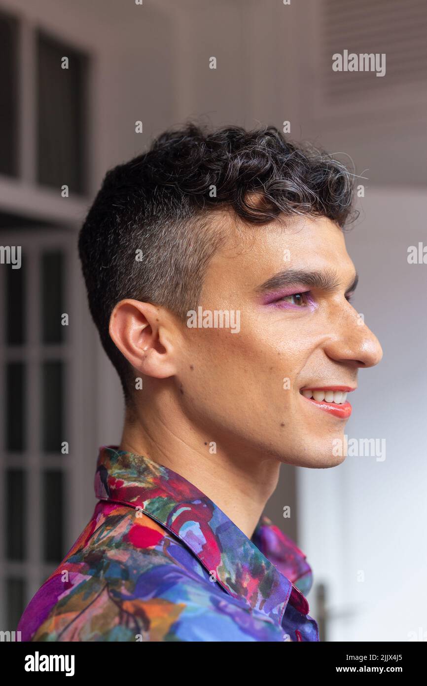 Side view of fashionable young transgender man with glitters on ...