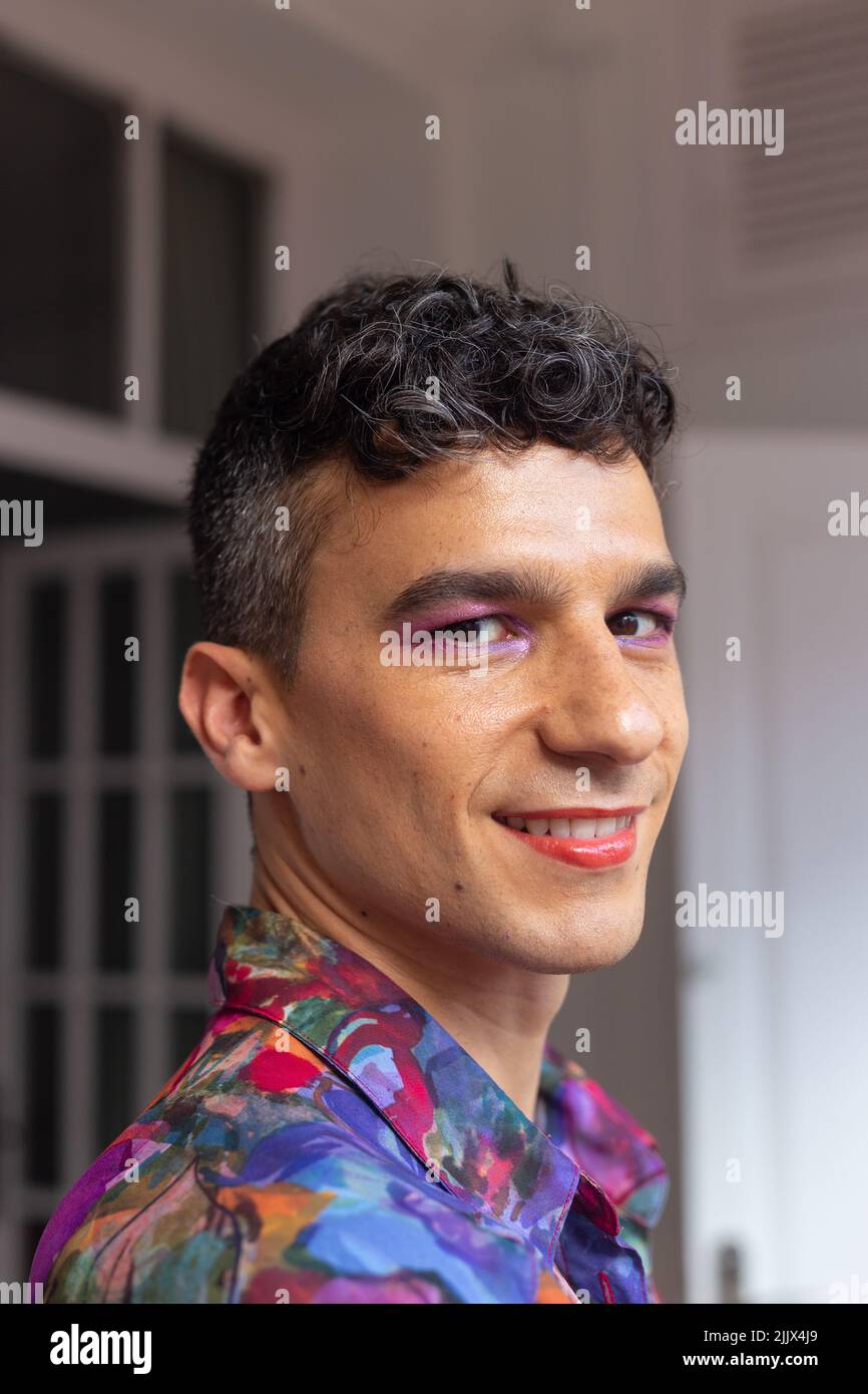 Side view of fashionable young transgender man with glitters on ...