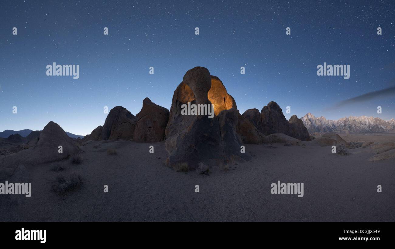 Rough stony formations and famous lightened Mobius arch located against ...