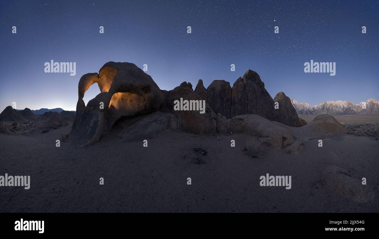 Rough stony formations and famous lightened Mobius arch located against ...