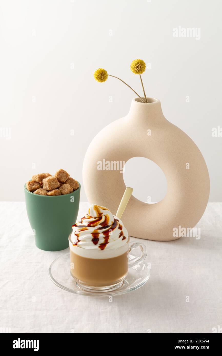 Caramel coffee latte in a dessert glass near brown sugar cubes and ...