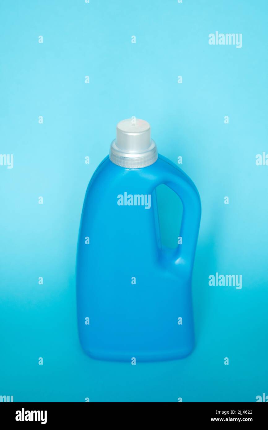 Blue plastic bottle with a grey cap isolated on blue background for ...