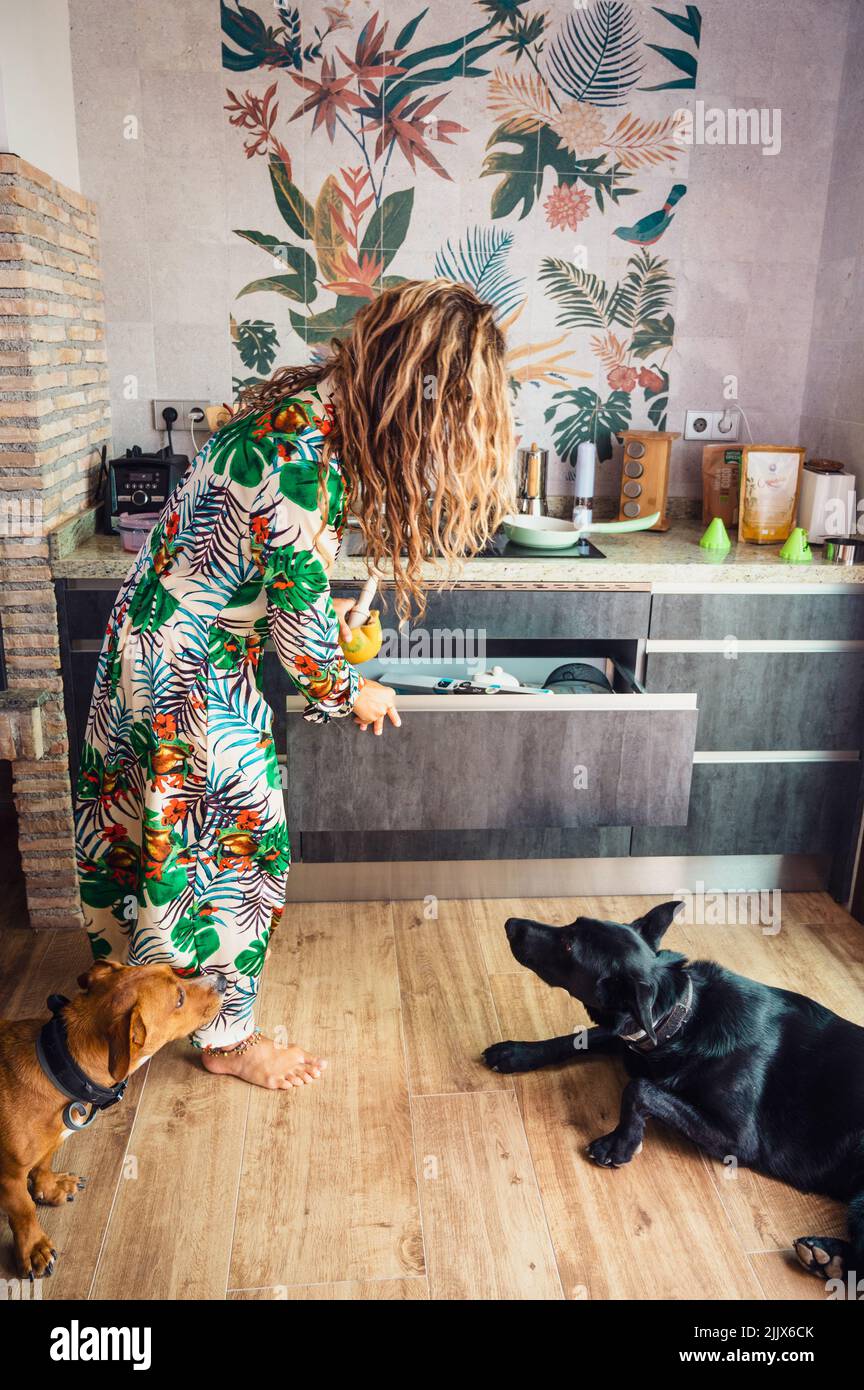 Loyal dog resting on floor near barefoot Woman in colorful dress ...